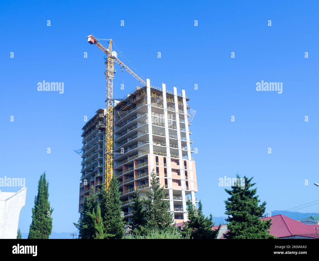 Crane and frame of a high concrete house. Construction works. Concrete ...