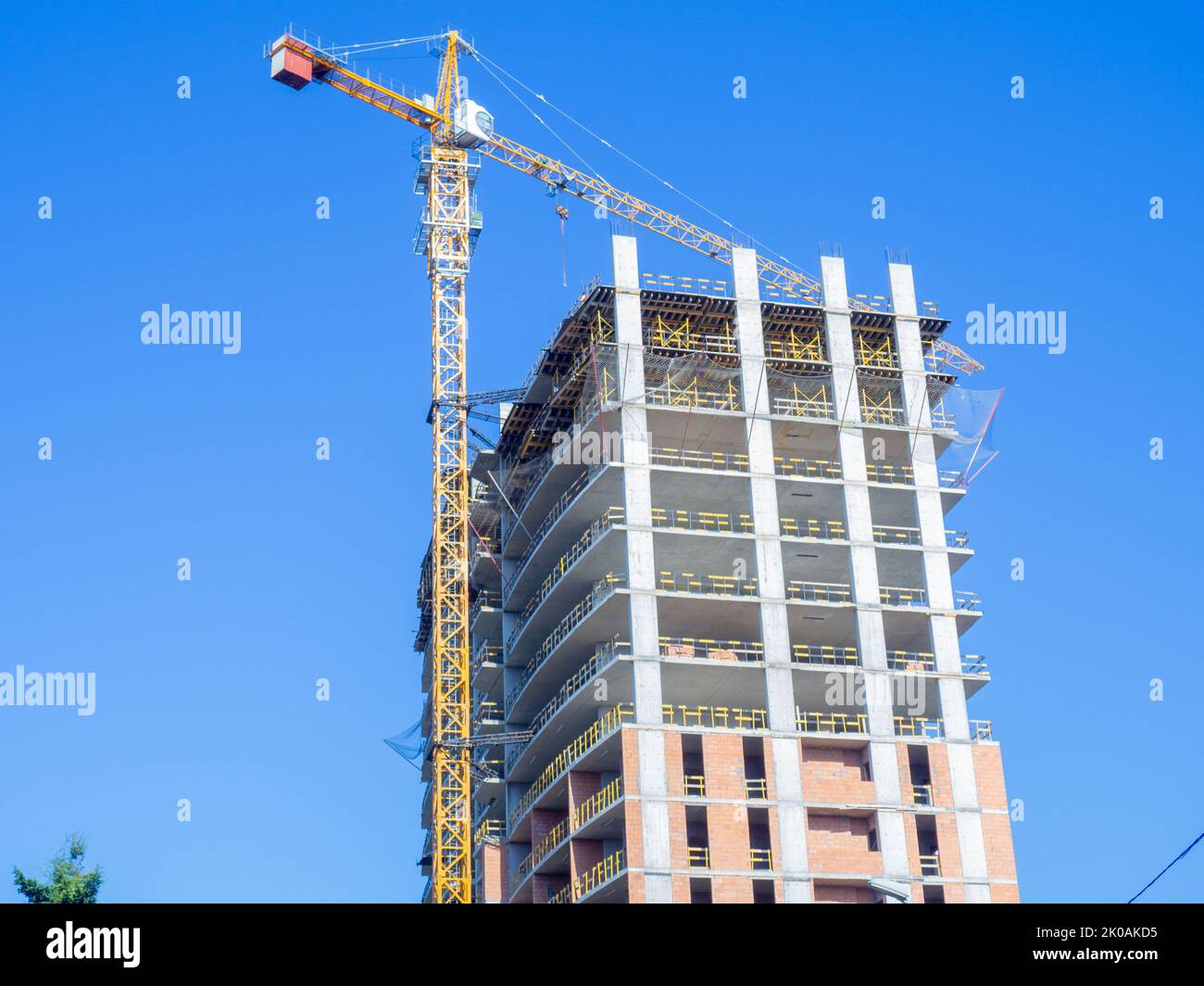 Crane and frame of a high concrete house. Construction works. Concrete ...