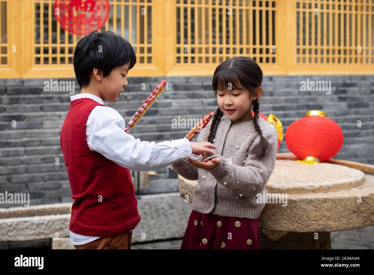 Happy Chinese sibling eating candied haws Stock Photo - Alamy