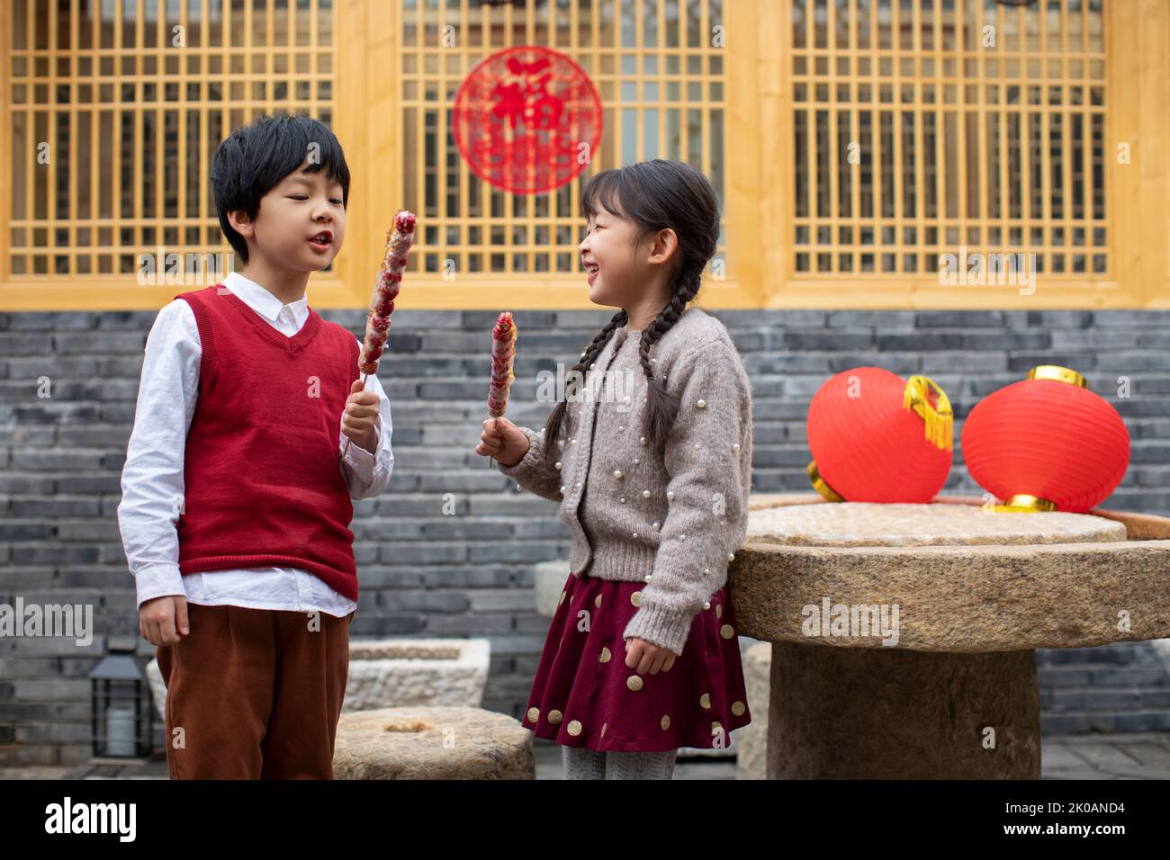 Happy Chinese sibling eating candied haws Stock Photo - Alamy