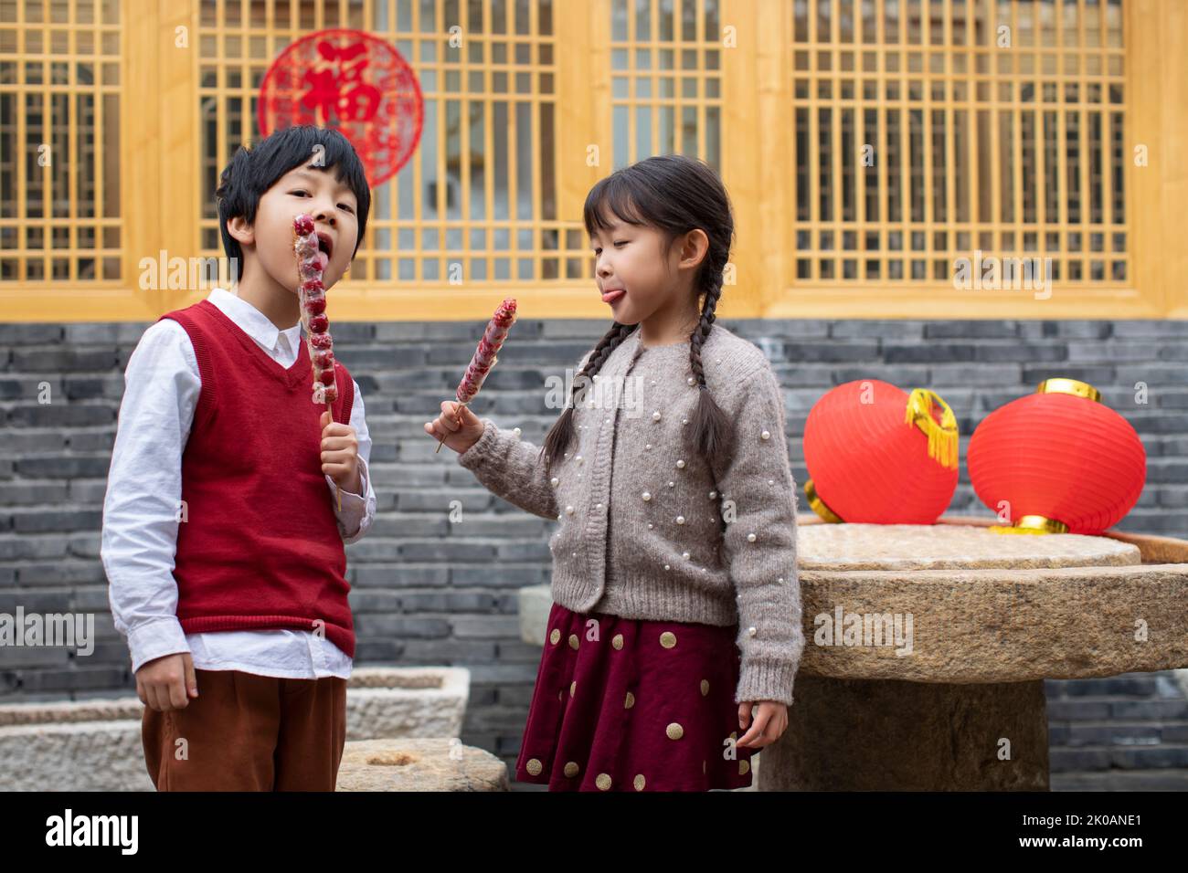 Happy Chinese sibling eating candied haws Stock Photo - Alamy