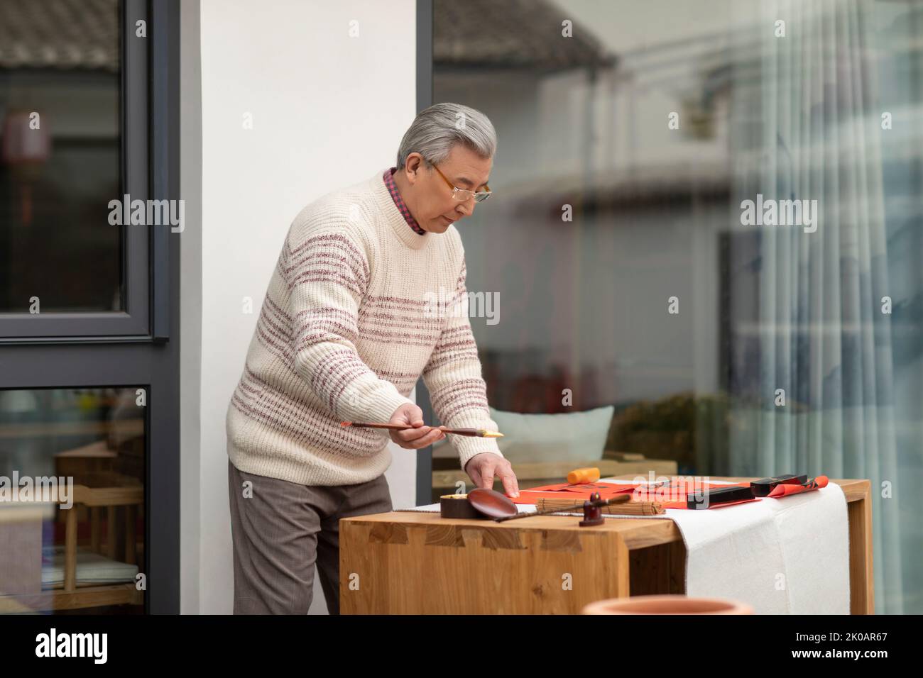 Happy senior Chinese man writing calligraphy on couplets Stock Photo ...