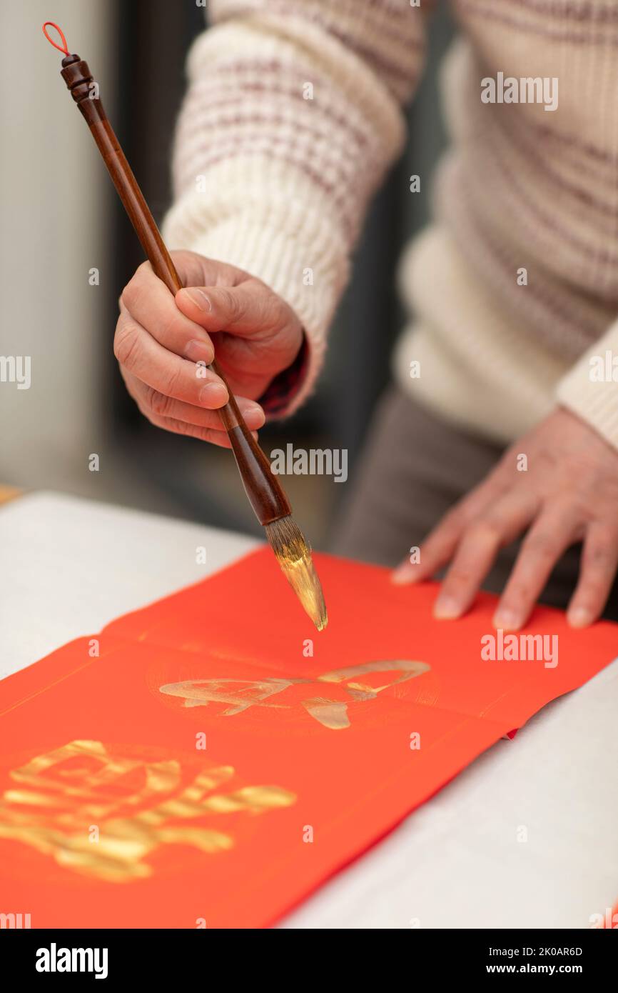 Happy senior Chinese man writing calligraphy on couplets Stock Photo ...