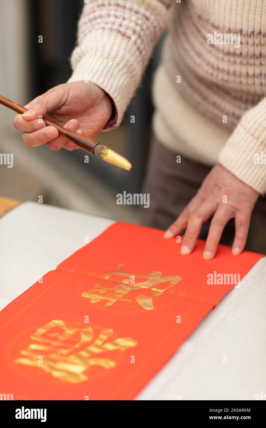 Happy senior Chinese man writing calligraphy on couplets Stock Photo ...