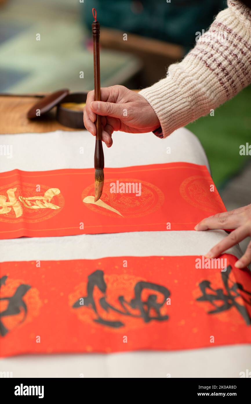 Happy senior Chinese man writing calligraphy on couplets Stock Photo ...