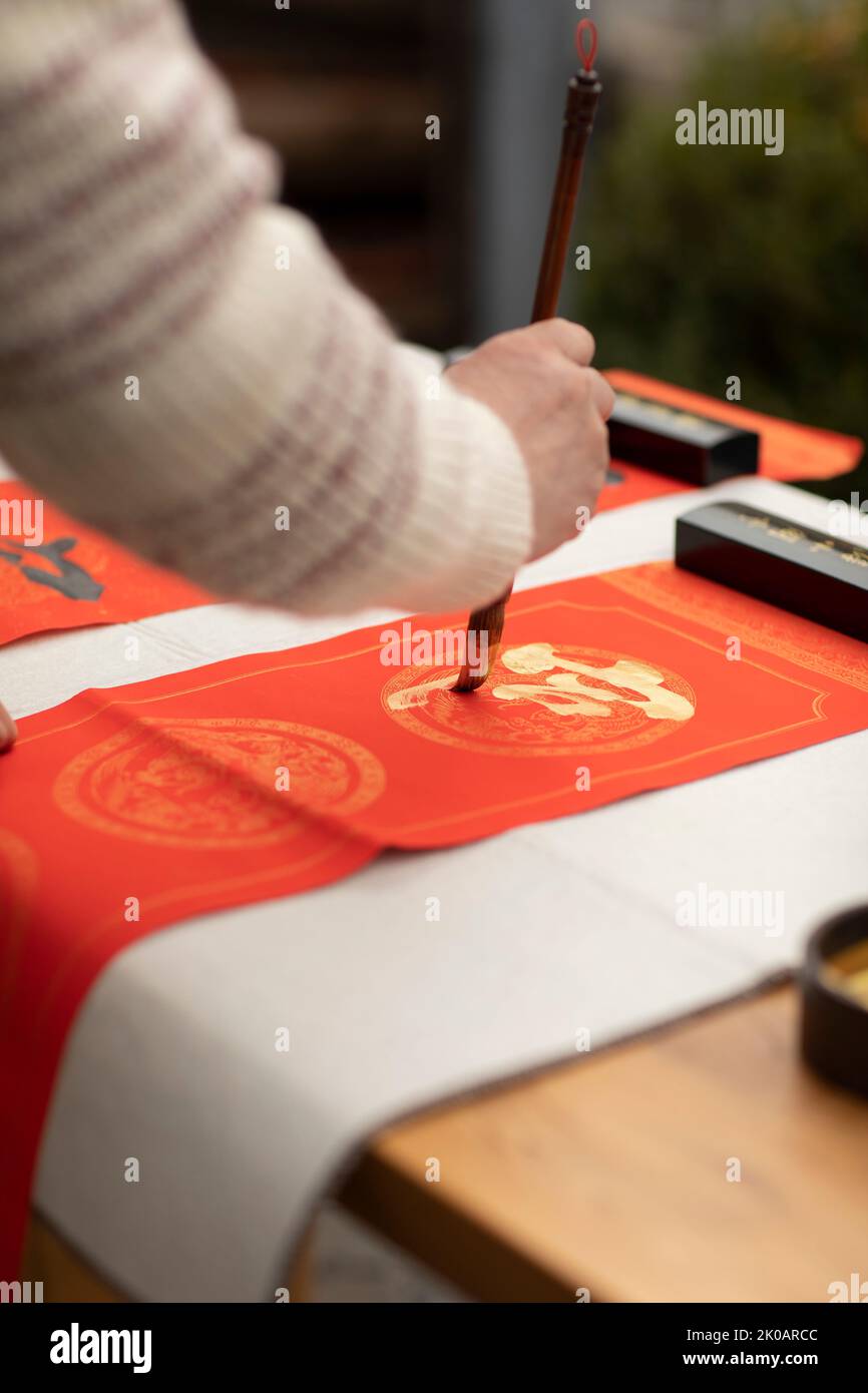 Happy senior Chinese man writing calligraphy on couplets Stock Photo ...