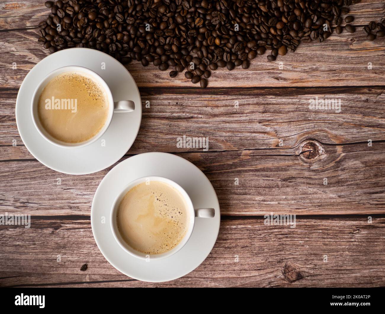 Two white cups with espresso on wood table with space to write. Top ...