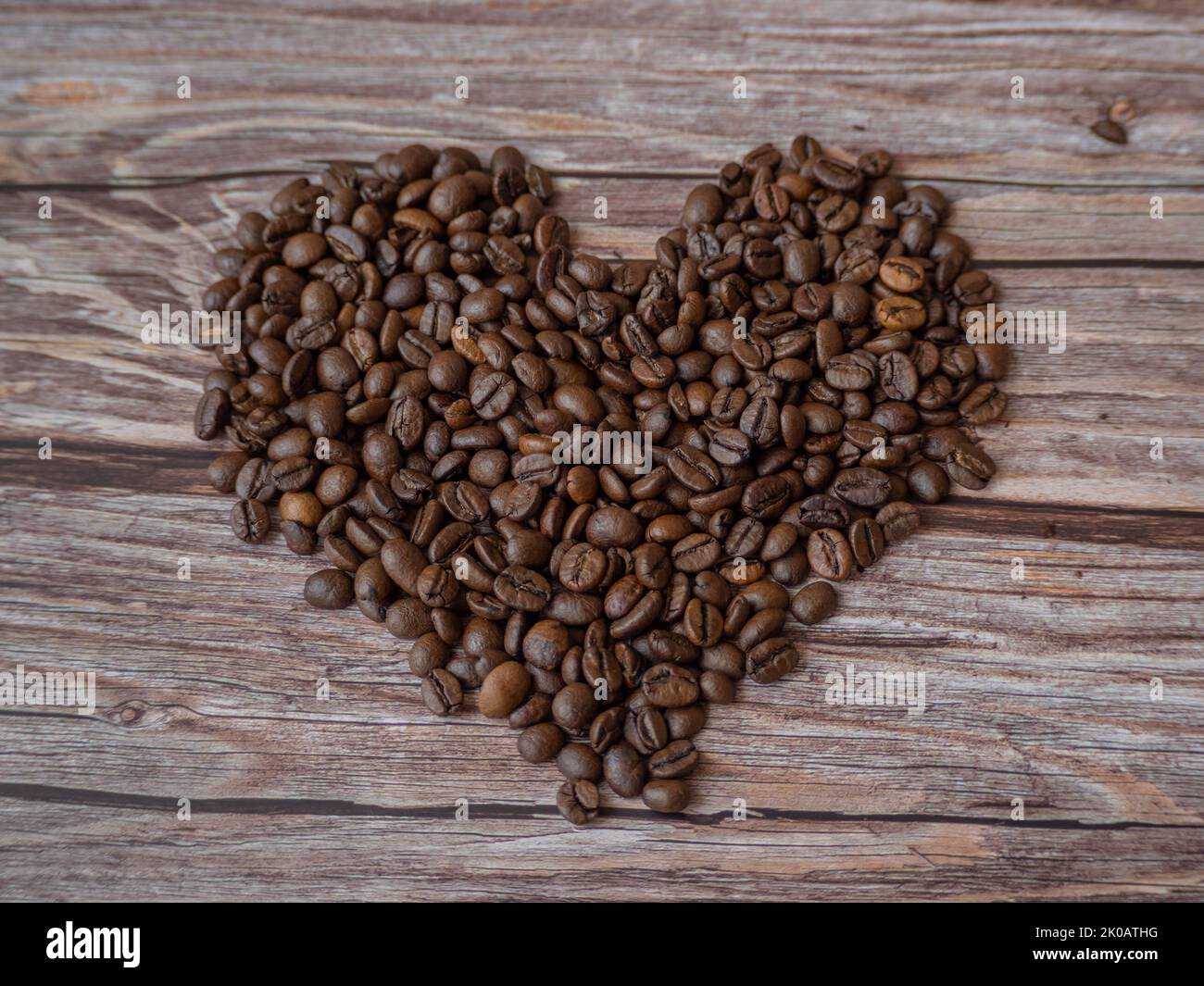 coffee beans forming a heart on wooden background. top view Stock Photo ...