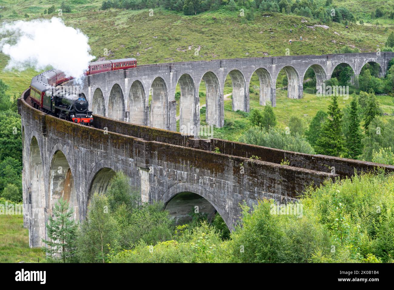 The Jacobite steam locomotive and ornate carriages,crossing the iconic ...