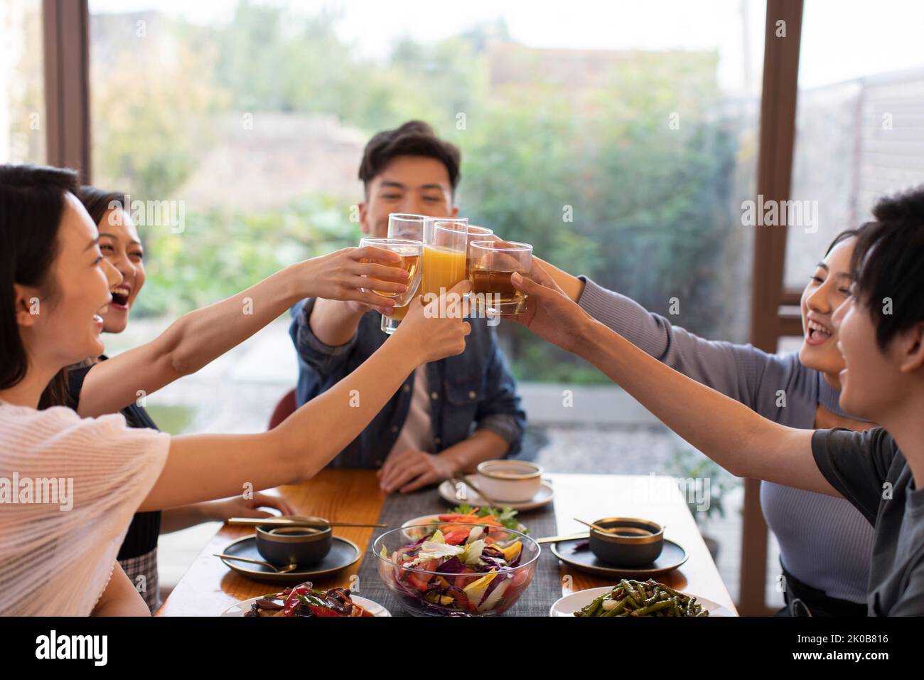 Young Chinese friends dining together at home Stock Photo - Alamy