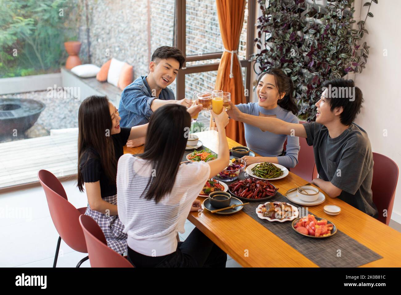 Young Chinese friends dining together at home Stock Photo - Alamy