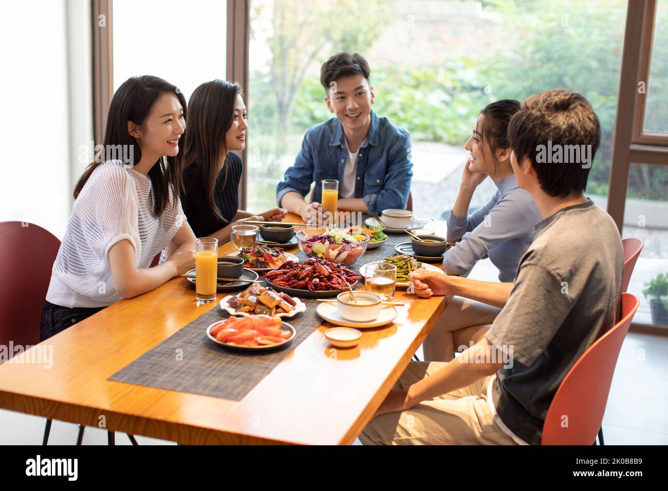 Young Chinese friends dining together at home Stock Photo - Alamy