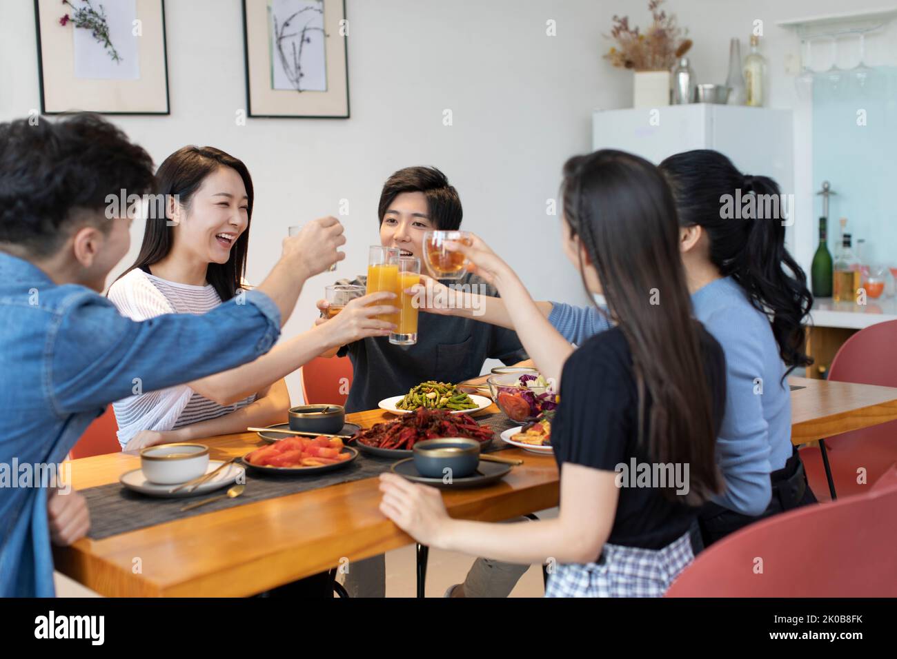 Young Chinese friends dining together at home Stock Photo - Alamy