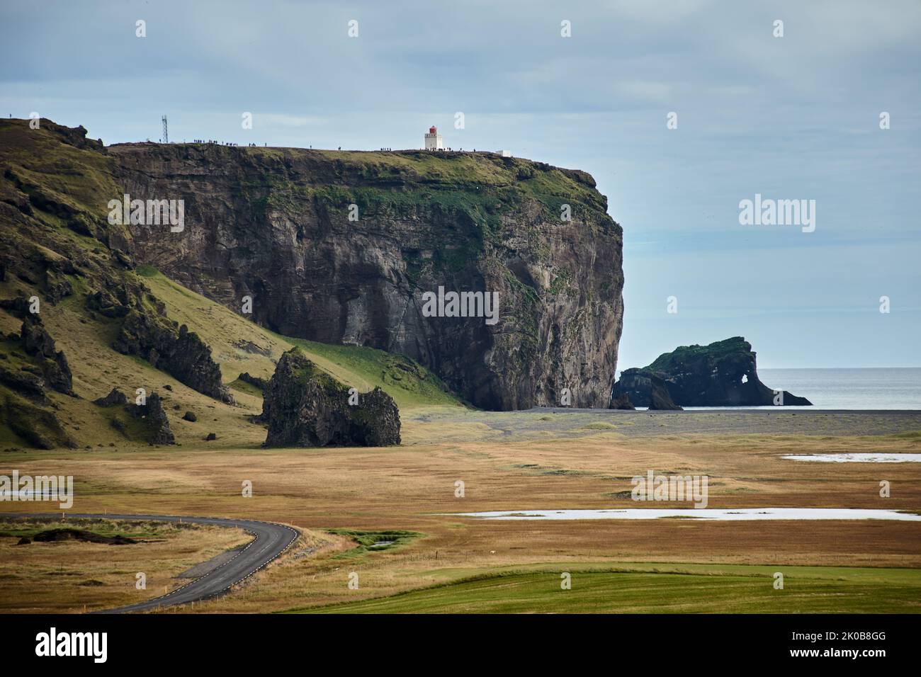 Rock, lighthouse and lava sea arch at Dyrholaey close to Vik village ...