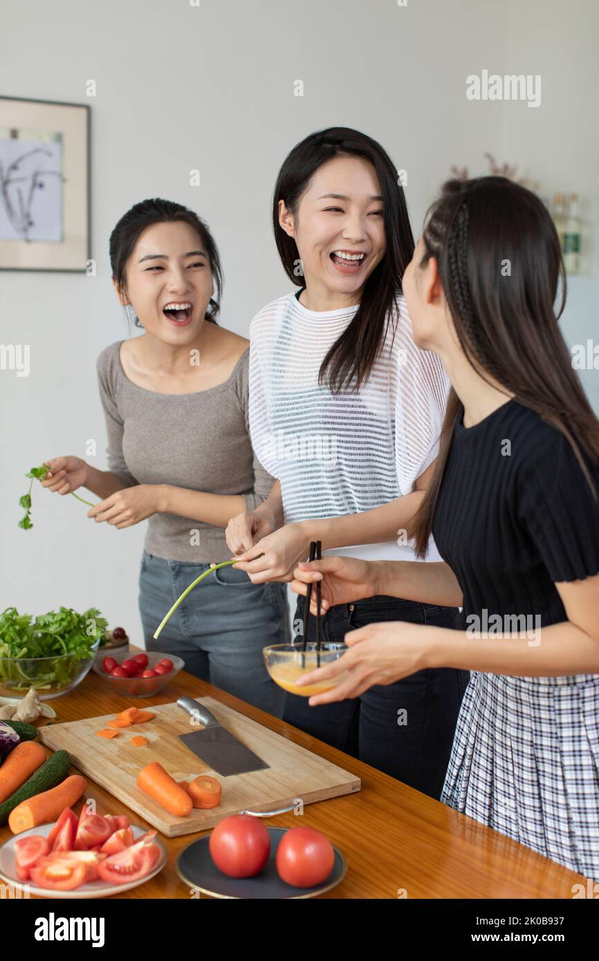 Young Chinese friends cooking in kitchen Stock Photo - Alamy