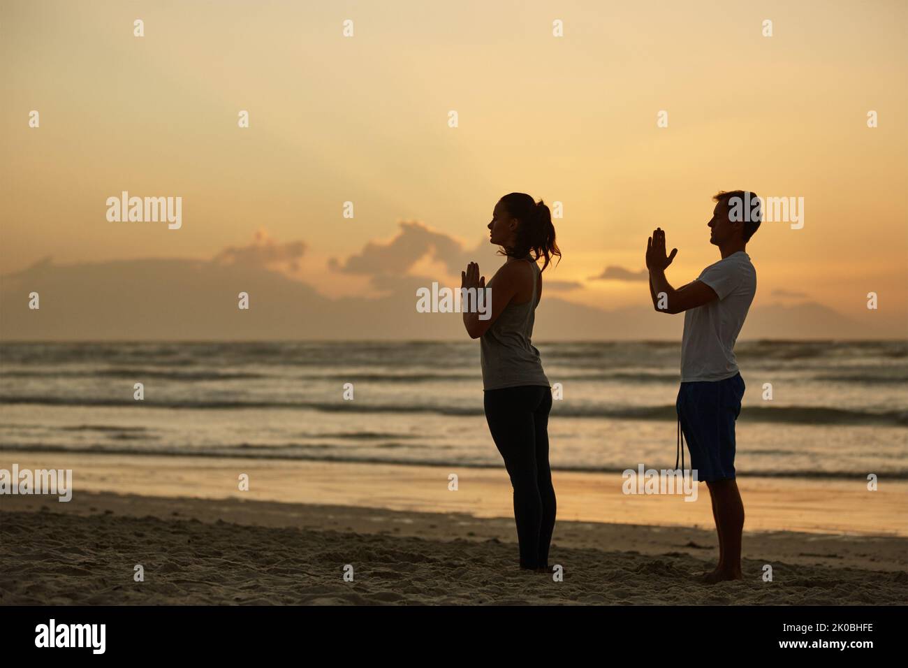 Enjoying the peace and tranquility of nature. a couple doing yoga on ...