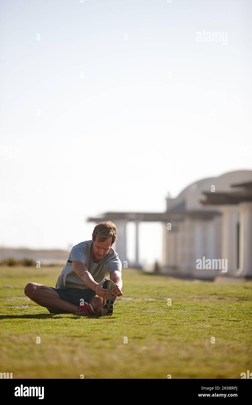 Stretching his hamstrings. a man doing stretches before his workout ...