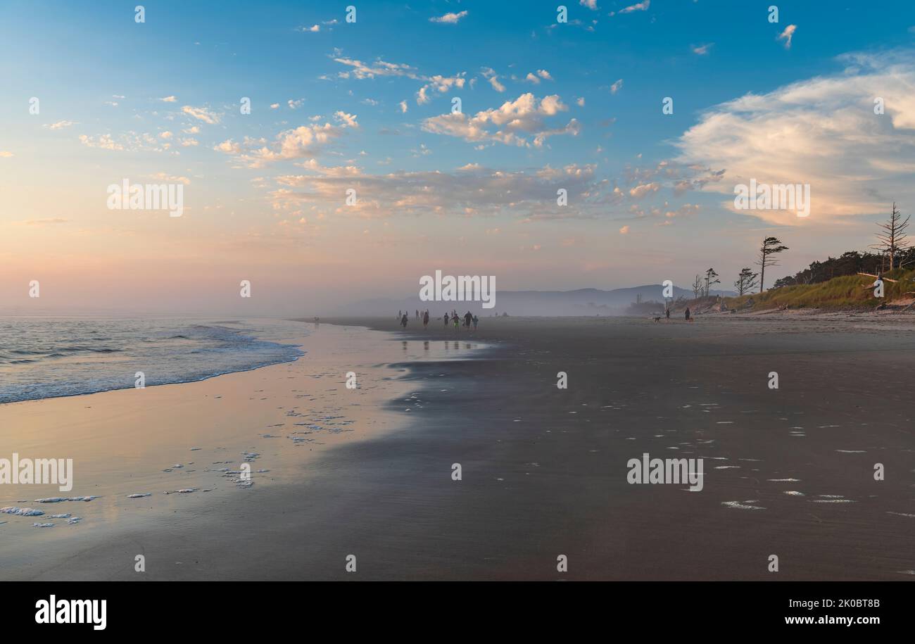 Pacific Coast visitors and families walking along the shore enjoying ...