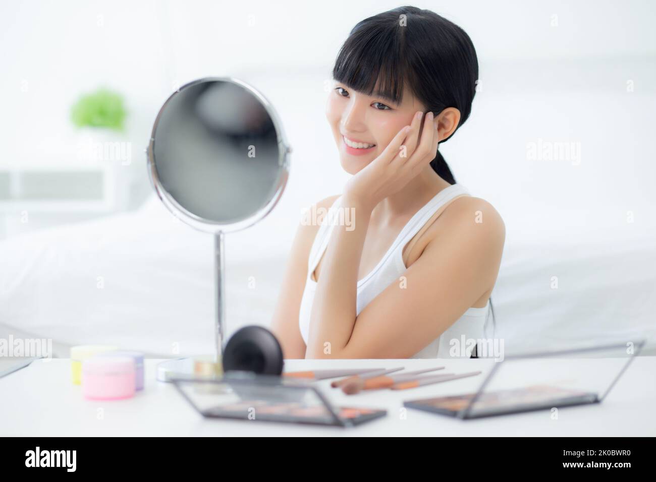 Beautiful face of young asian woman with happy smiling and touch cheek ...