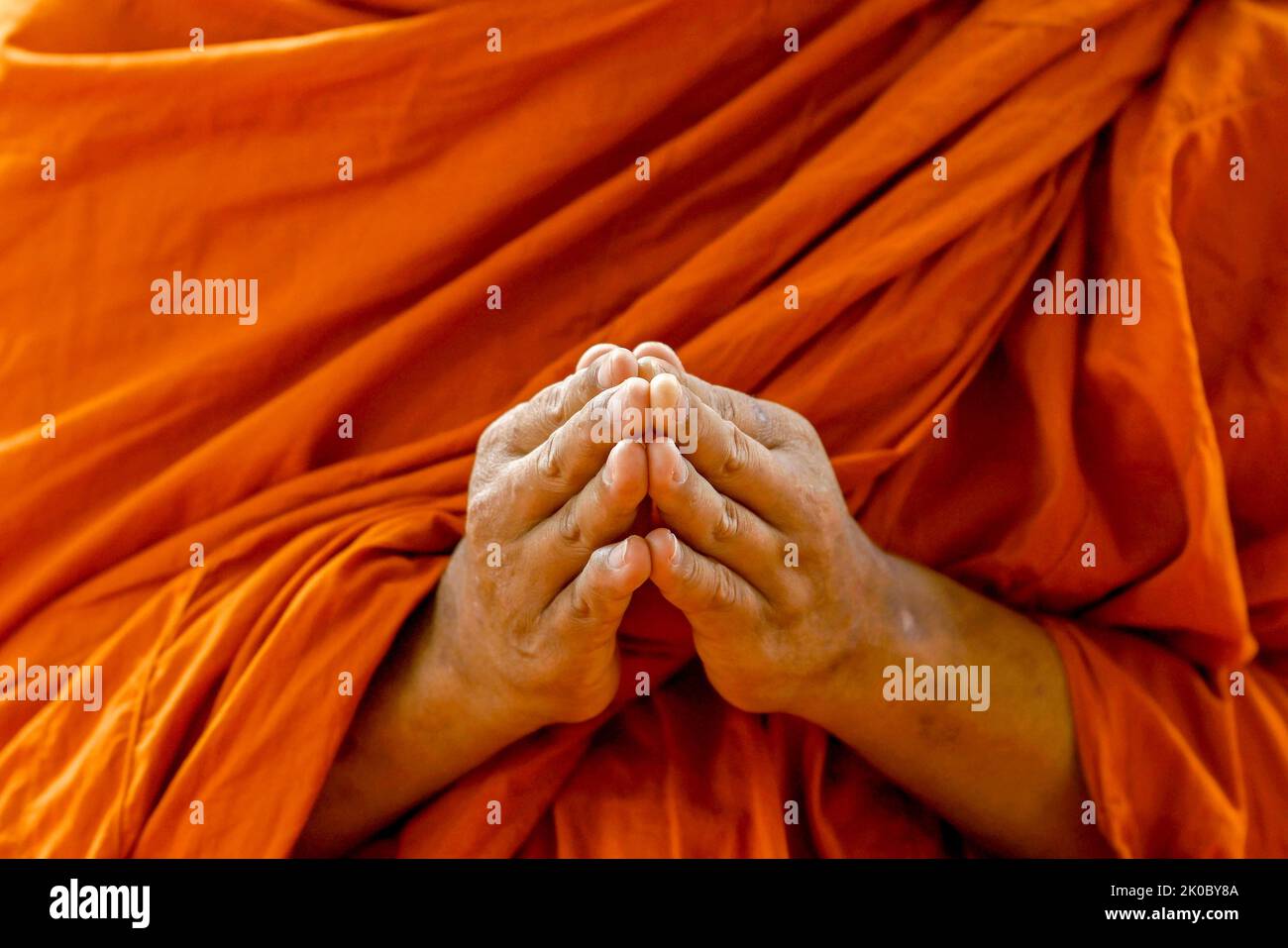 A close up view of a Thai monk's wai, the clasping of hands in prayer ...