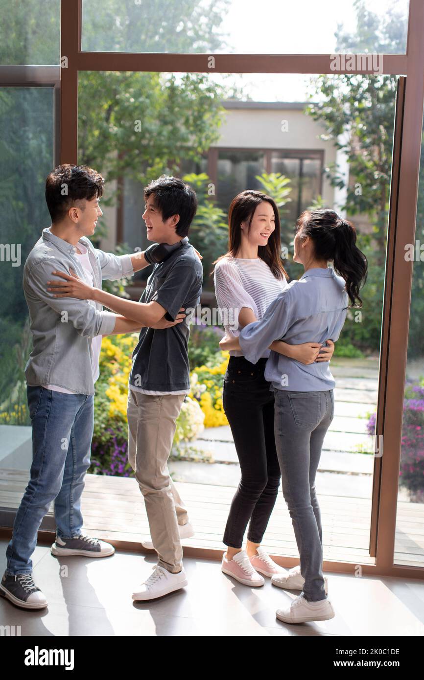 Young Chinese couple welcoming guests for party Stock Photo - Alamy