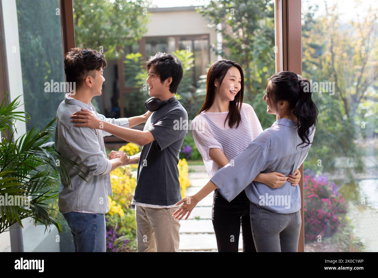 Young Chinese couple welcoming guests for party Stock Photo - Alamy