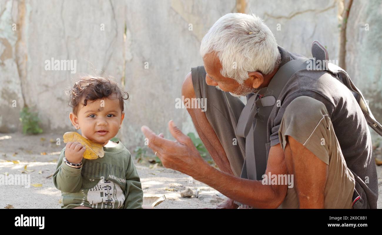 Indian Senior grandfather with toddler grandson siting in nature and ...