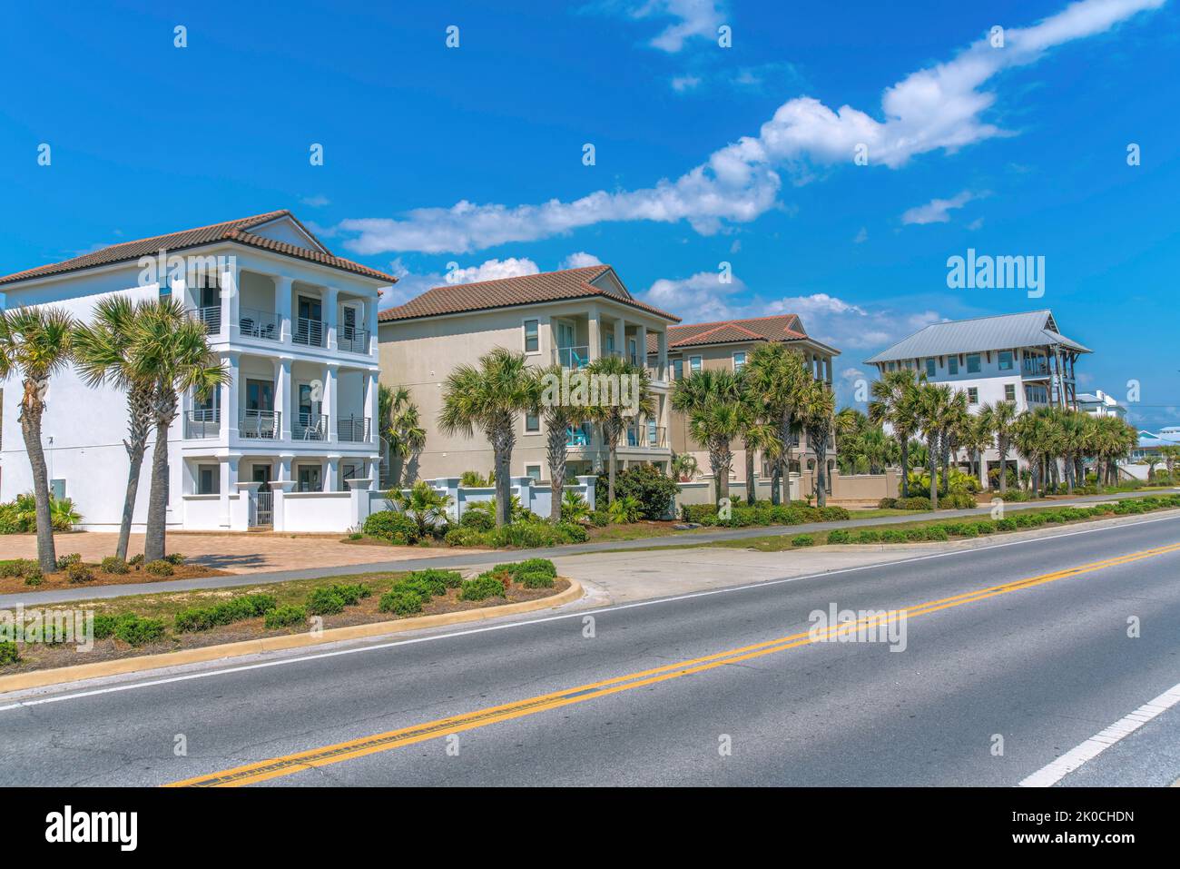 Three-storey beach houses with balconies and palm trees near a beach at ...
