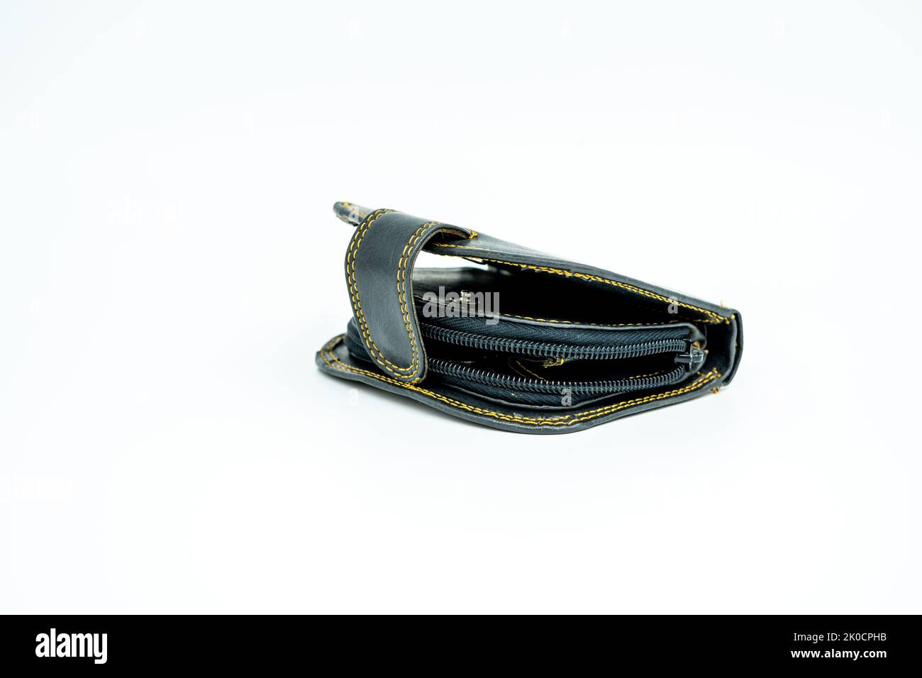 Black leather clip-on wallet with yellow thread on a white background ...