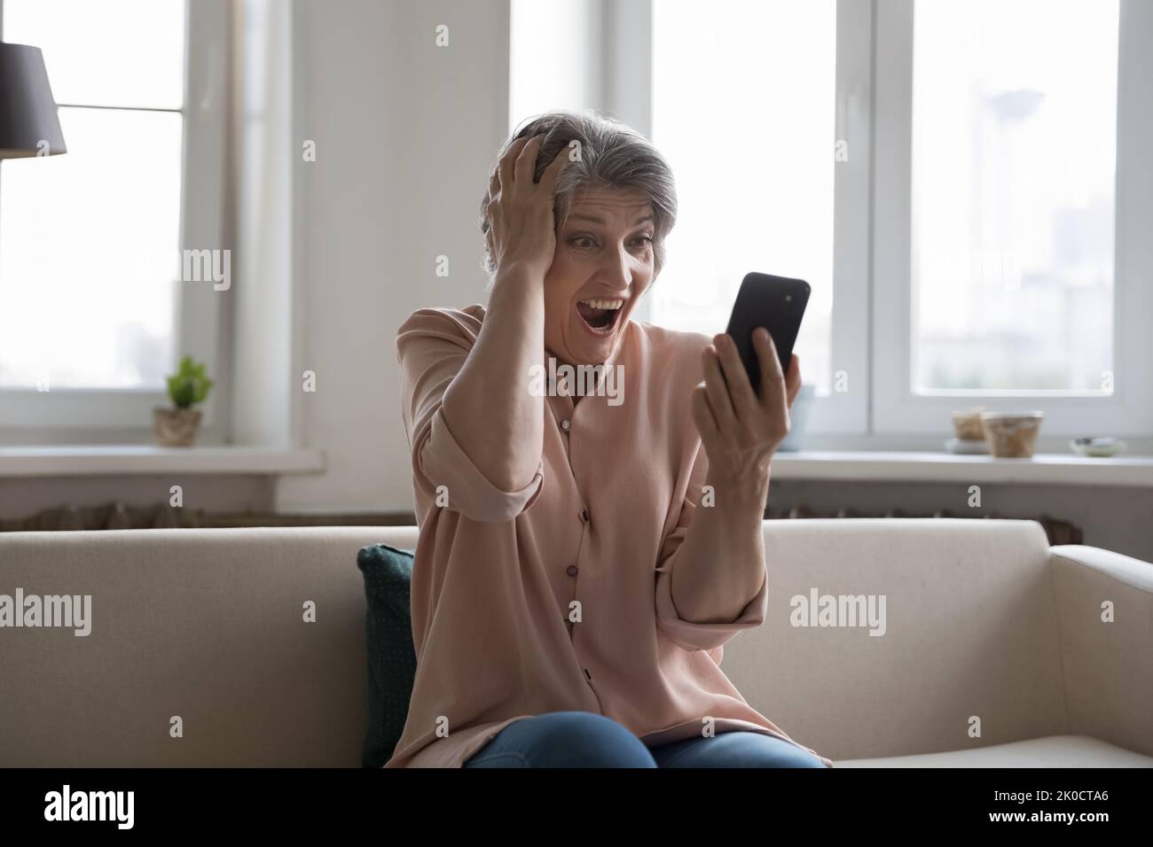 Excited mobile phone user woman shocked with good surprising news Stock ...