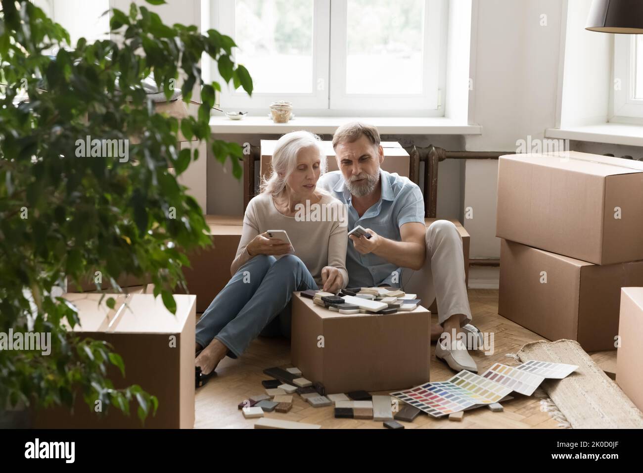 Elder grey haired family couple of new homeowners reviewing samples ...