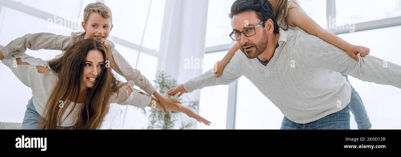 cheerful parents play with their children in a bright living roo Stock ...