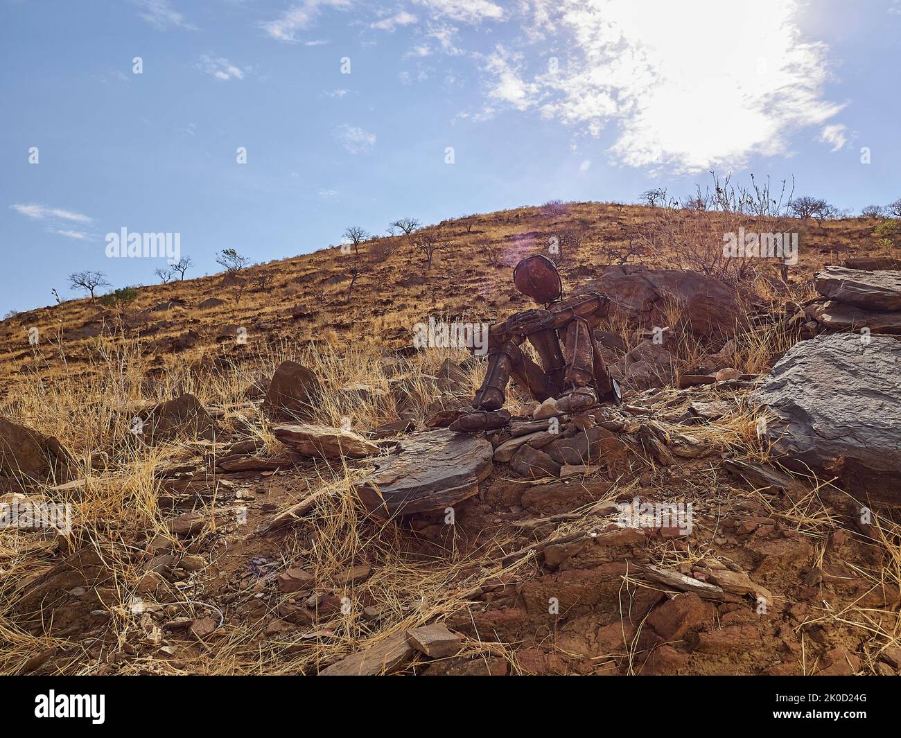 Lone man rock sculpture sitting on the side of the road in Namibia ...