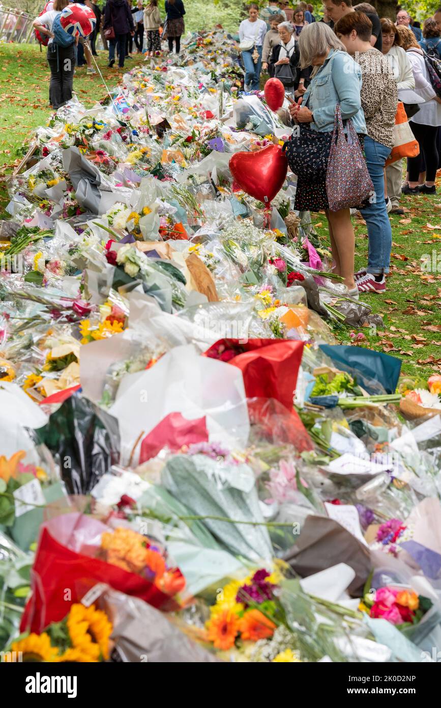People pausing to read messages on the mounds of flowers in Green Park ...