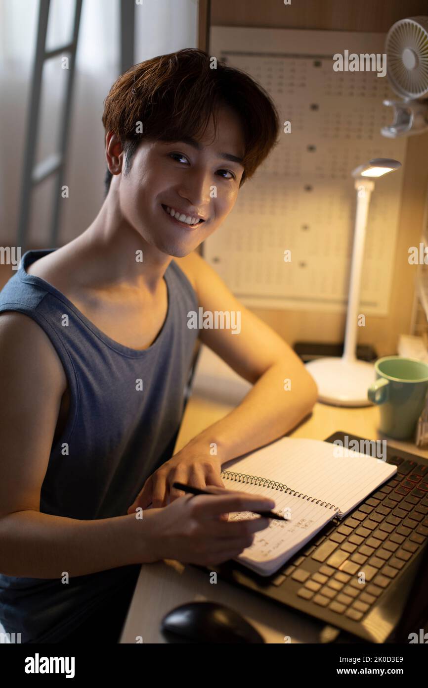 Young Chinese university student using laptop in dormitory Stock Photo ...