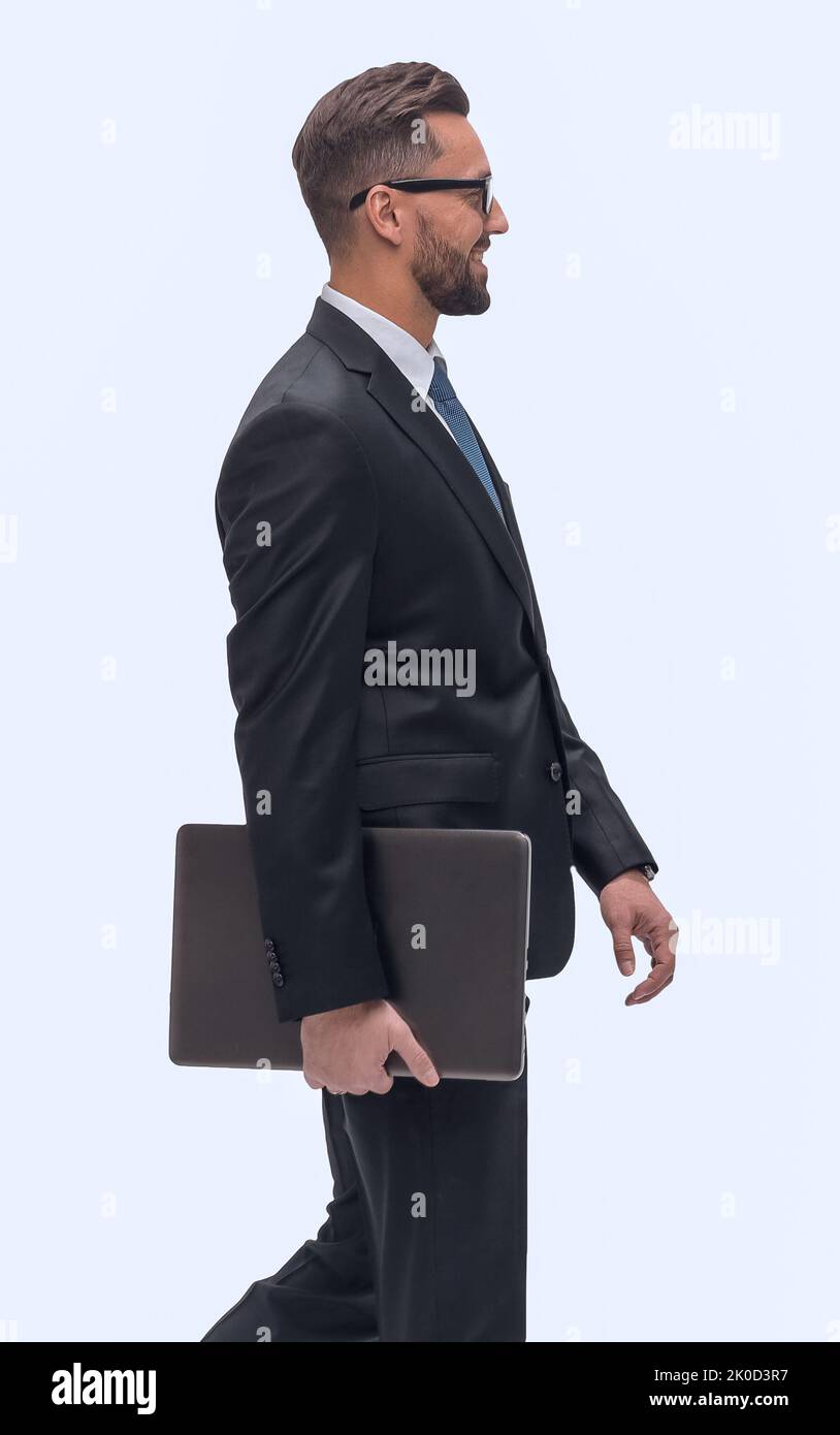 in full growth. successful businessman with laptop stepping forward ...