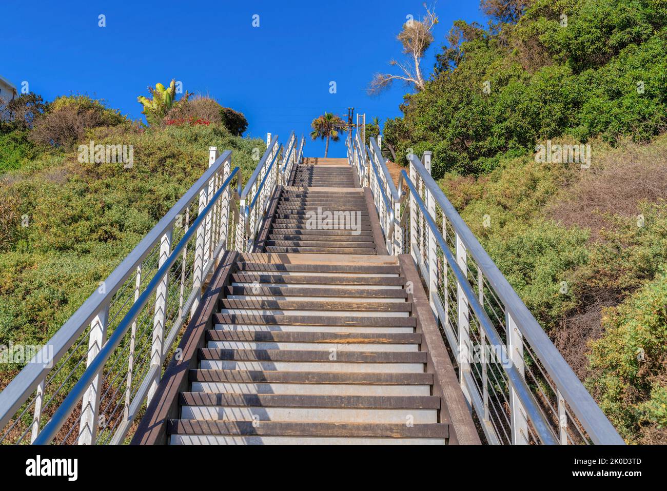Straight outdoor staircase with metal railings on a mountain slope at ...