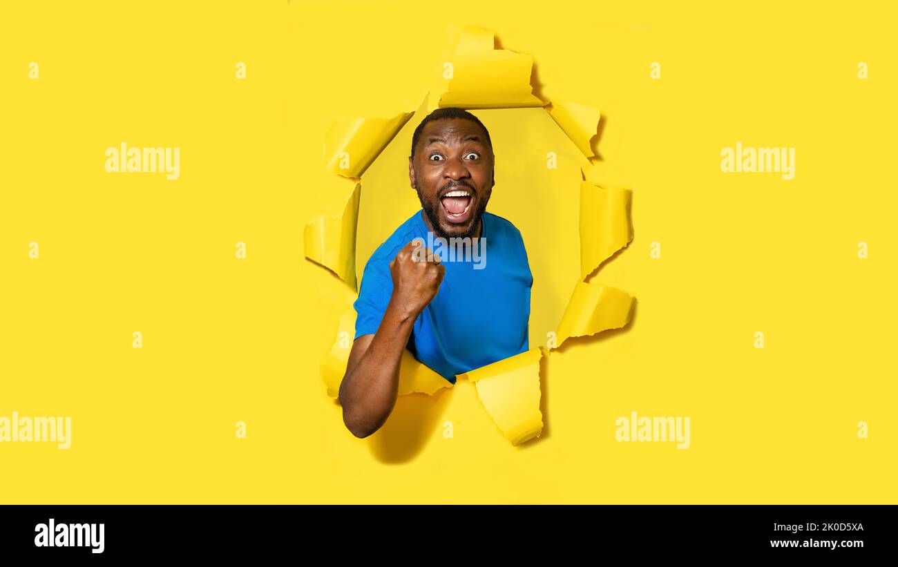 Excited african american man raising clenched fist and opening mouth ...
