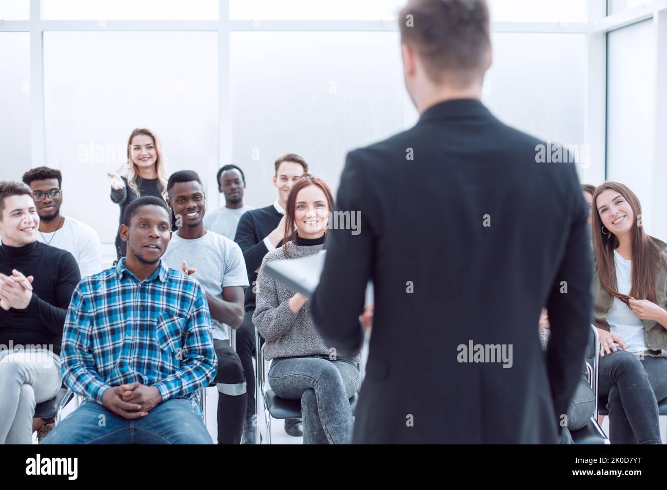 speaker and a group of diverse young listeners in a conference room ...