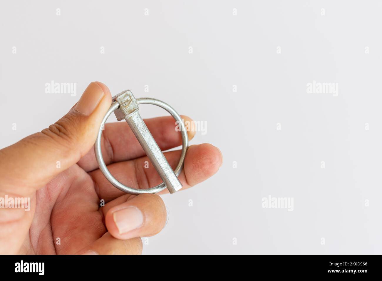 Lynch pin holding in hand on a white background with selective focus ...