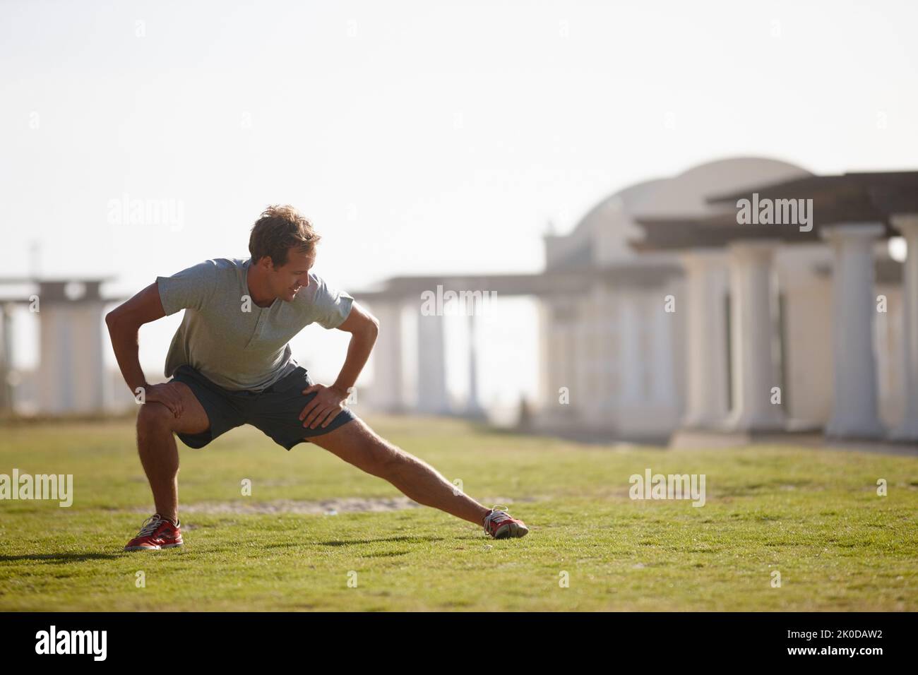 Getting a good stretch in. a man doing stretches before his workout ...