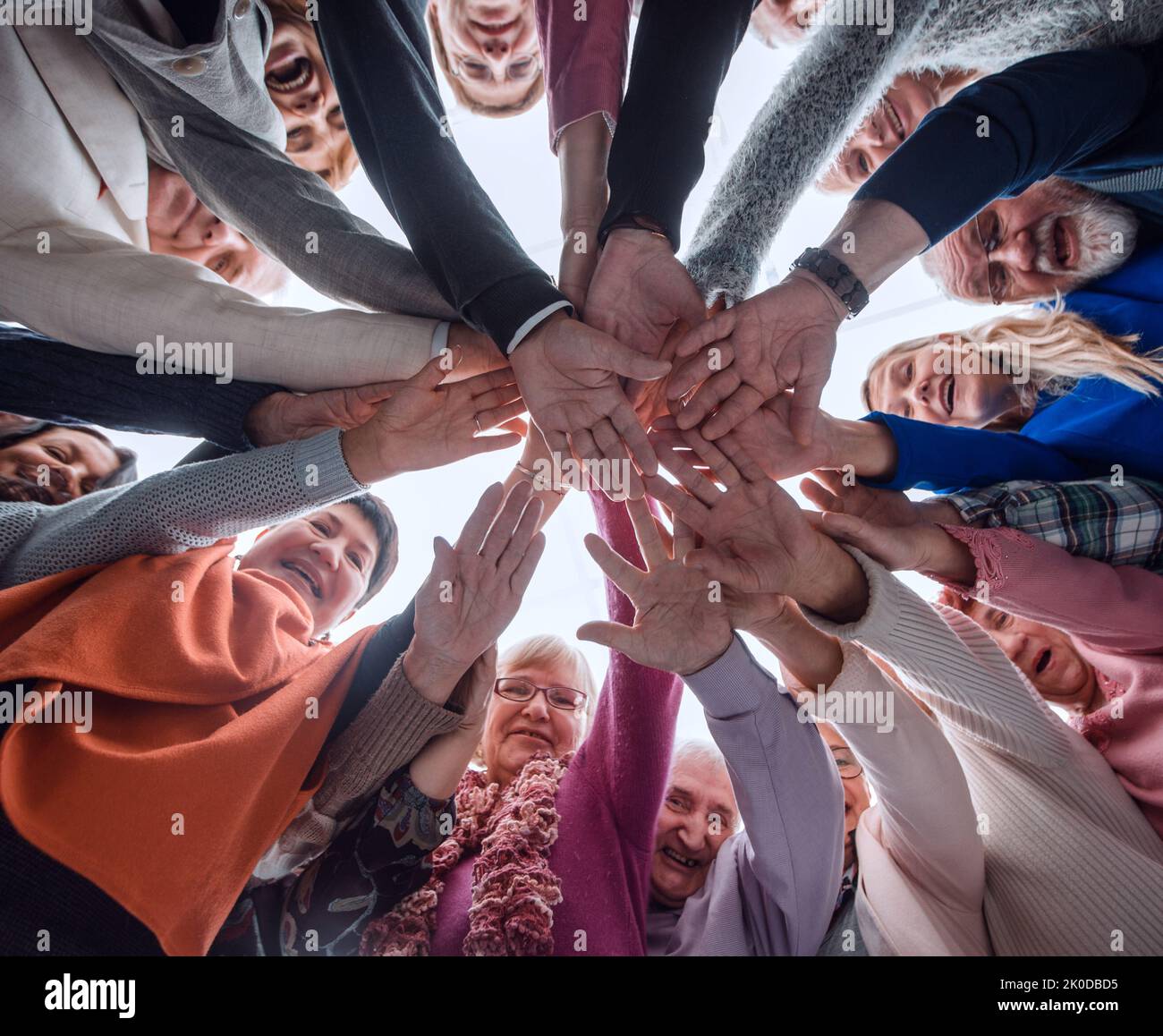 Creative business team stacking hands together in office Stock Photo ...