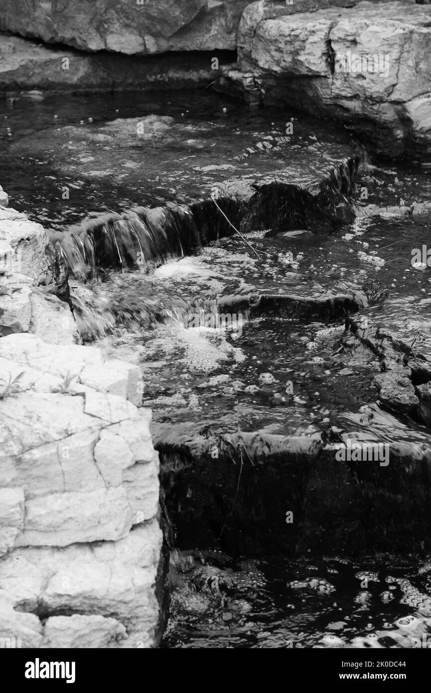 A bubbling creek running over the rocks and stones in a black and white ...