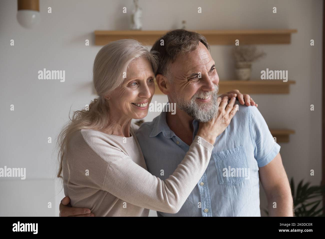 Cheerful Older Mature Married Couple Hugging At Home With Love Stock