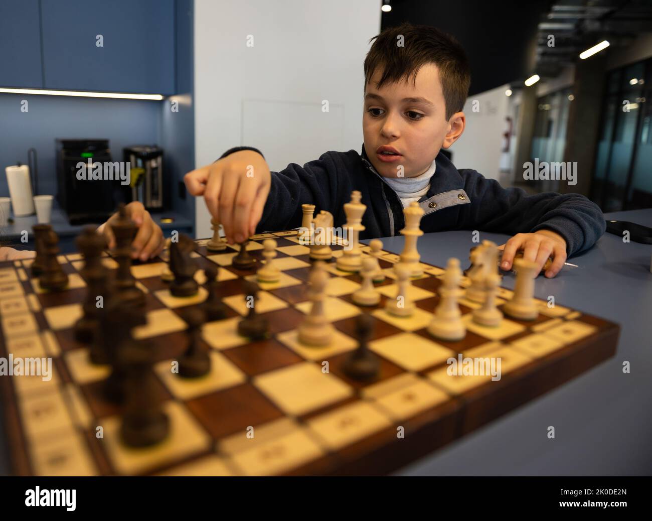 Concentrated Caucasian school boy developing chess strategy, playing ...