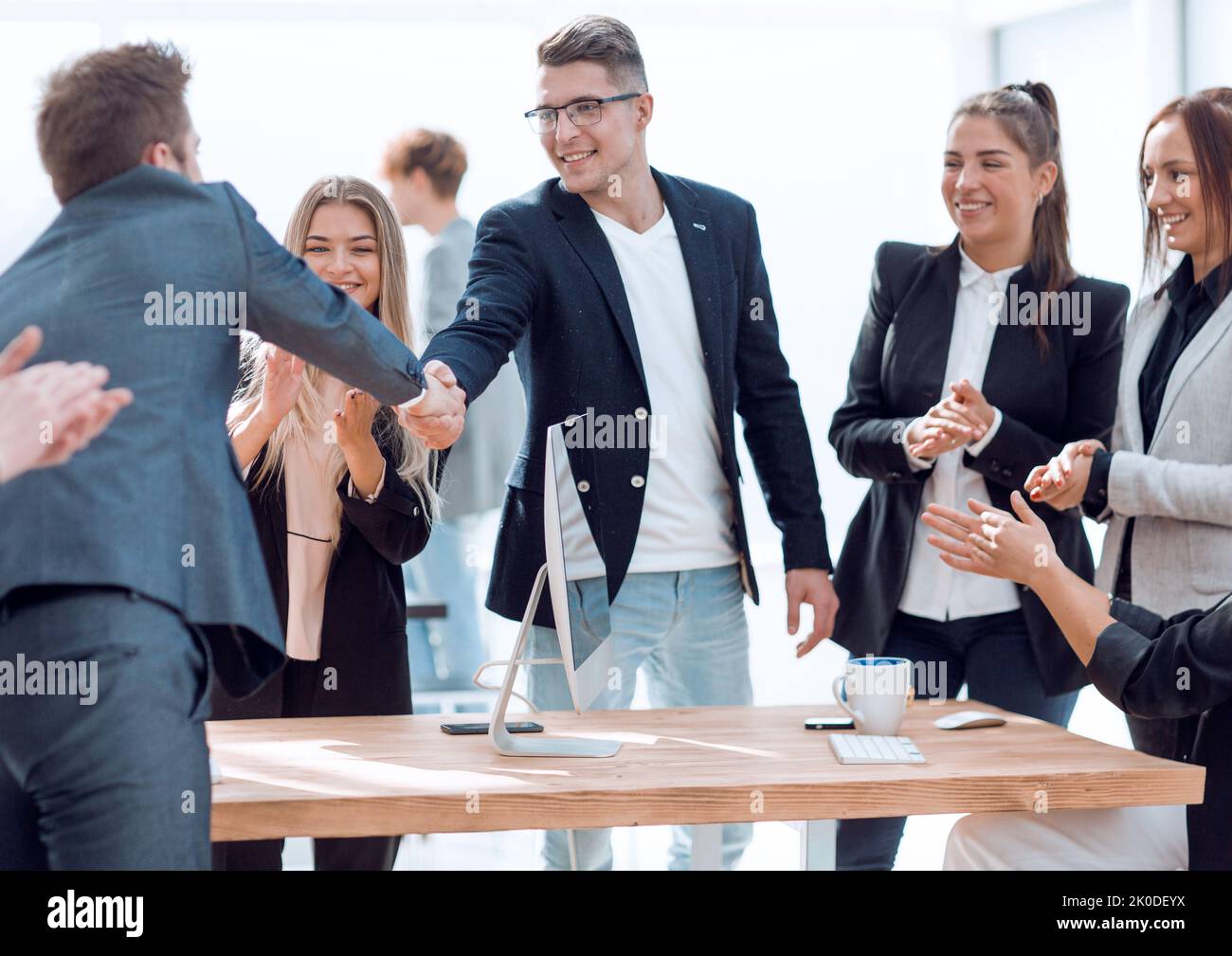 two young women shaking hands near an office Desk Stock Photo - Alamy