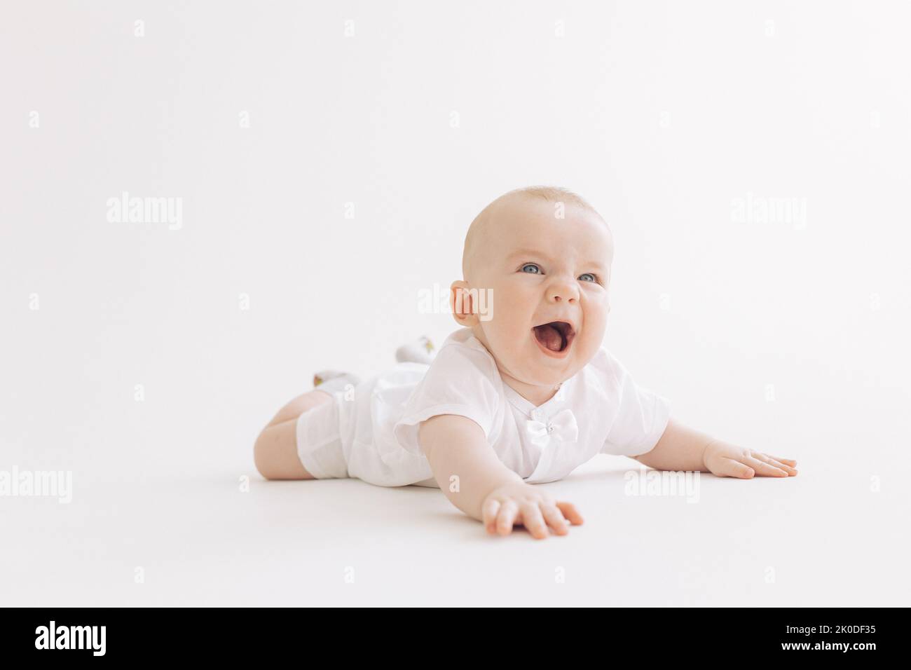 Happy baby boy laughs cheerfully lying against white background Stock Photo - Alamy