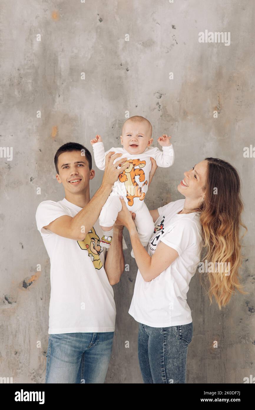Young happy parents play with their baby boy and smile Stock Photo - Alamy