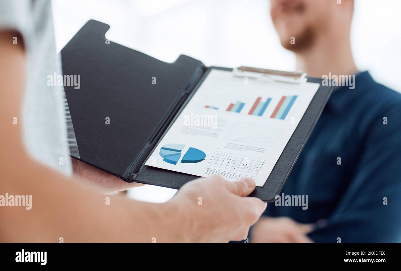 close up. financial chart is in the hands of a young employee Stock ...