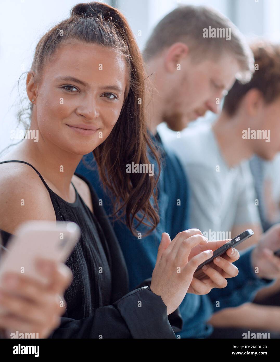 group of serious young people looking at their smartphone screens Stock ...